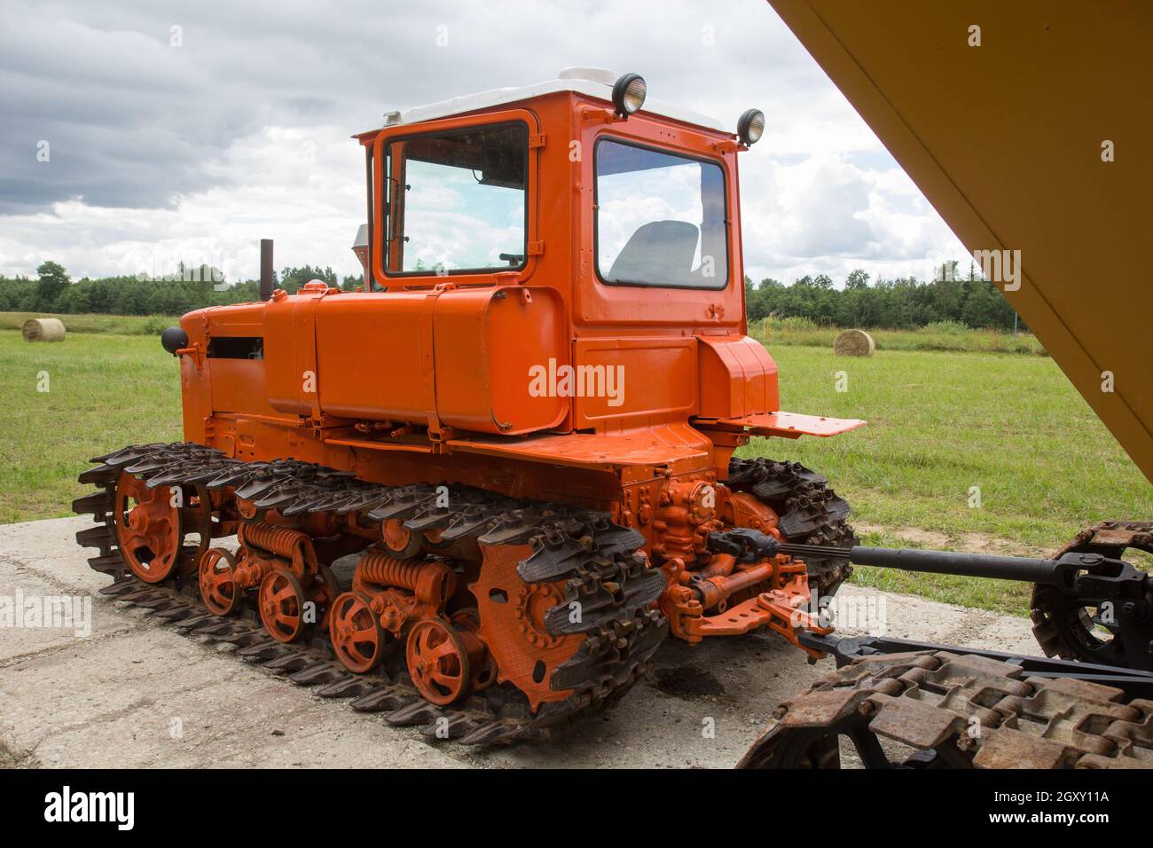 Old red tracked tractor standing near field Stock Photo - Alamy