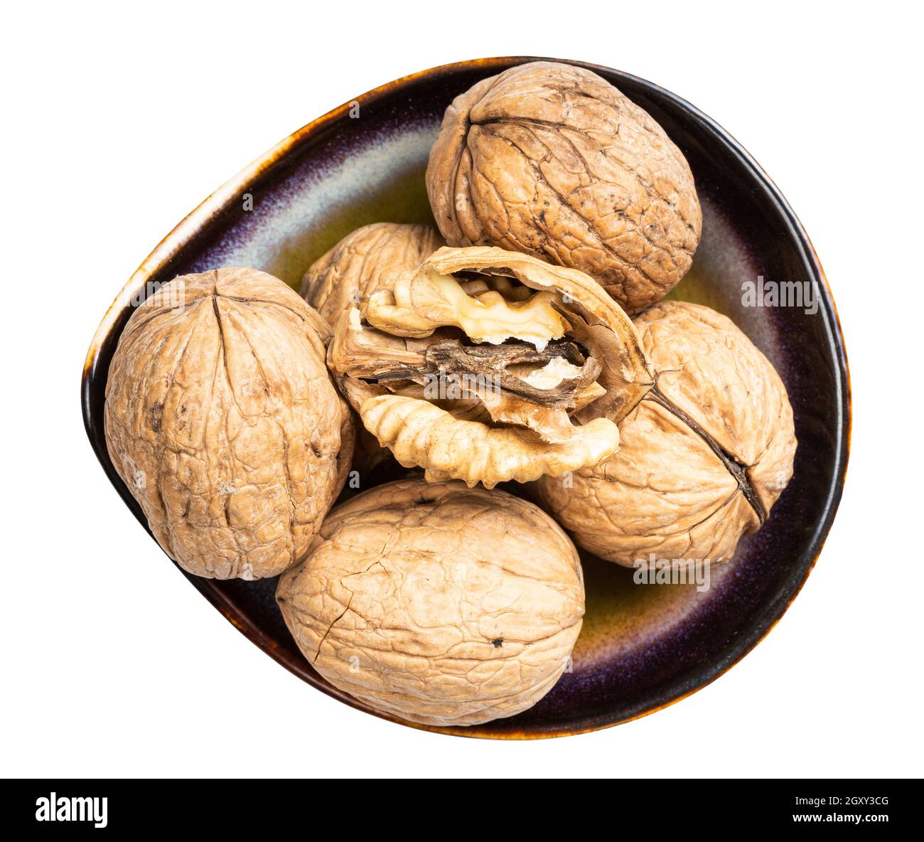 top view of shelled and whole walnuts in ceramic bowl isolated on white ...