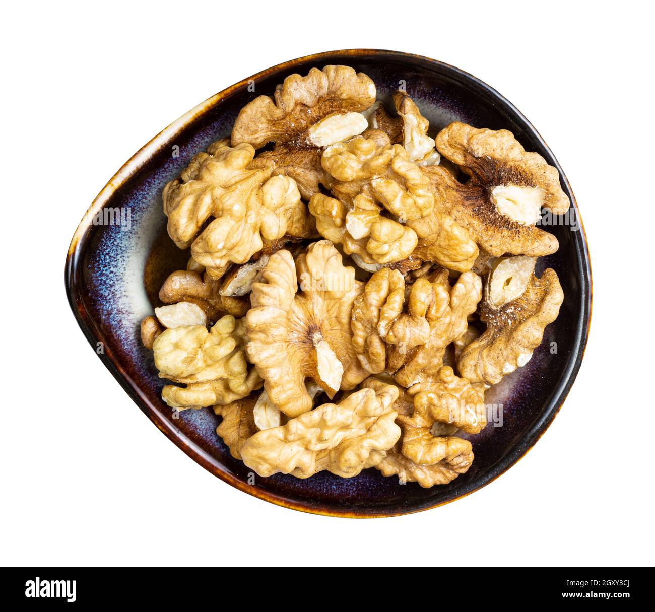 top view of peeled walnuts in ceramic bowl isolated on white background ...