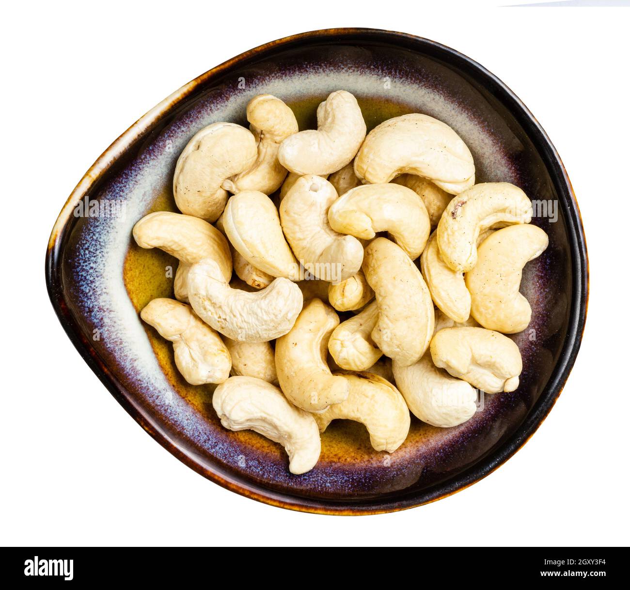 top view of raw cashew seeds in ceramic bowl isolated on white ...