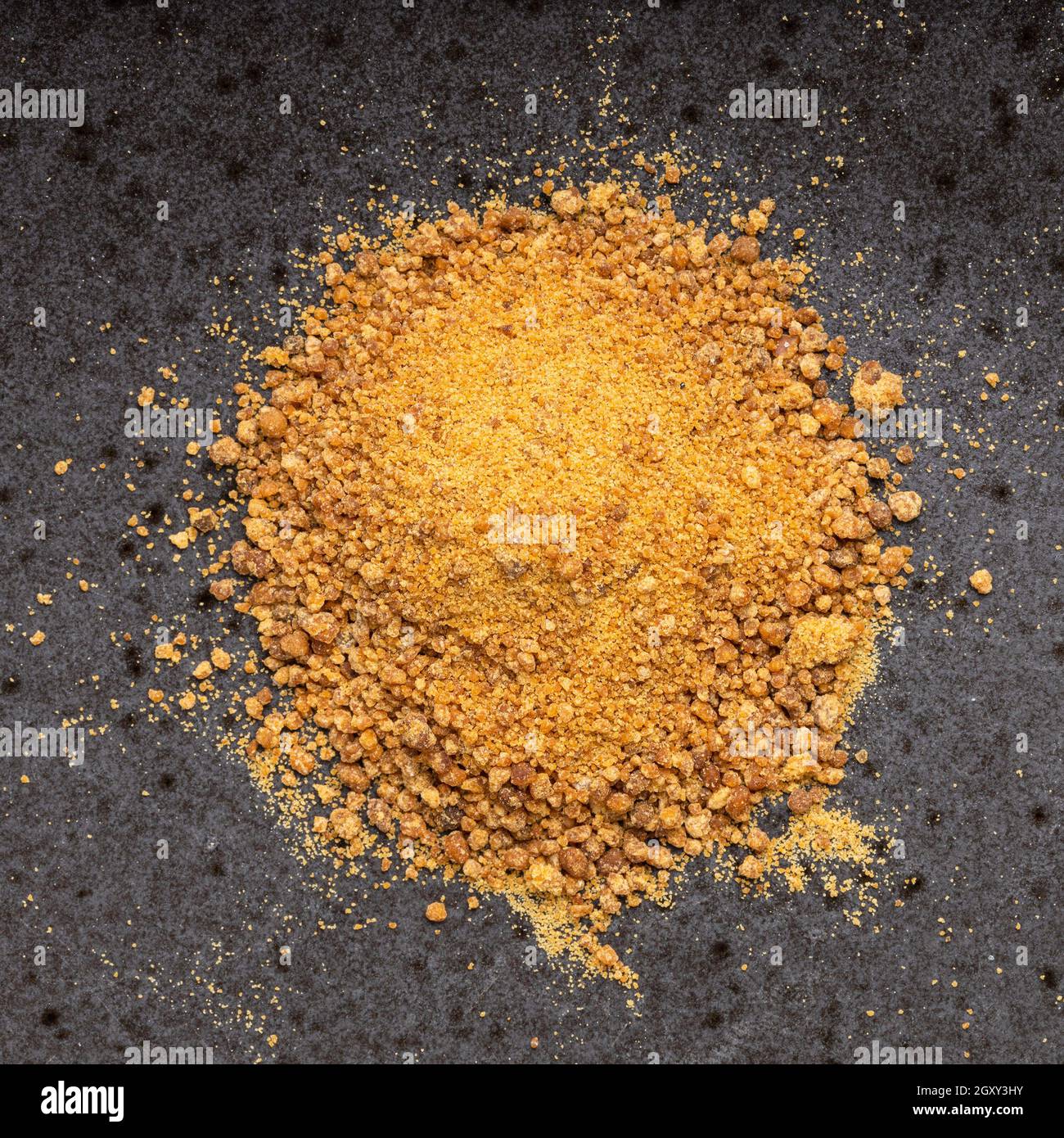 pile of granulated coconut blossom sugar close up on black ceramic ...