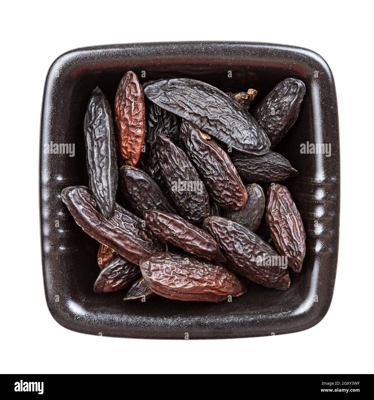 top view of dried tonka beans in black bowl isolated on white ...