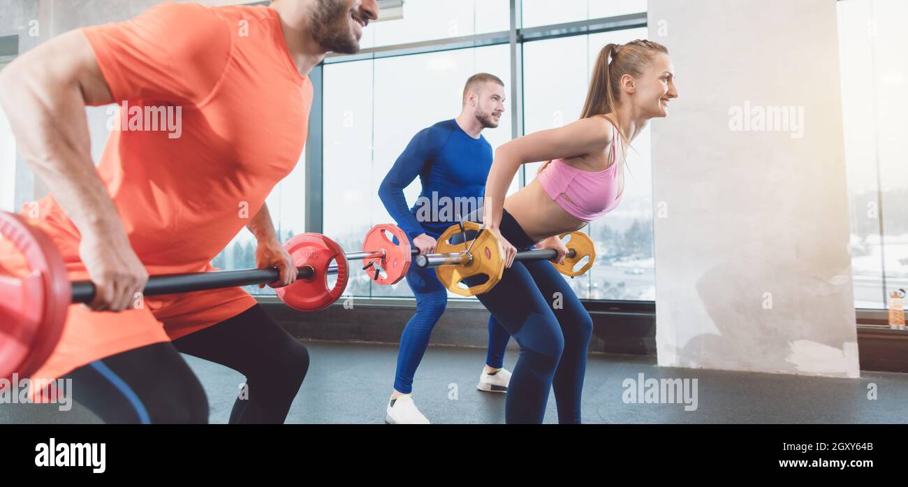 People with barbells in the gym training their biceps muscle lifting ...