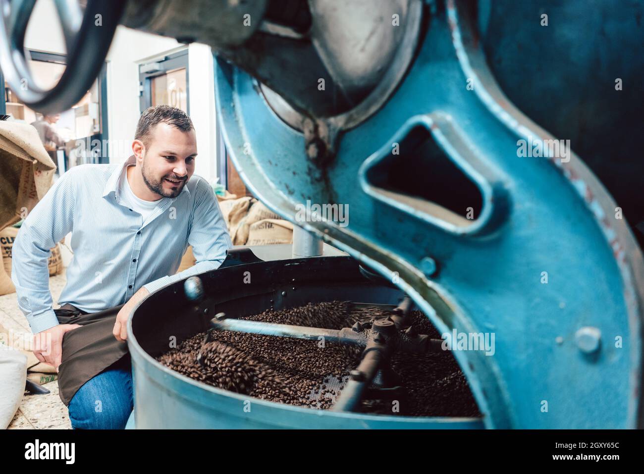 Man operating coffee roaster in his factory Stock Photo - Alamy