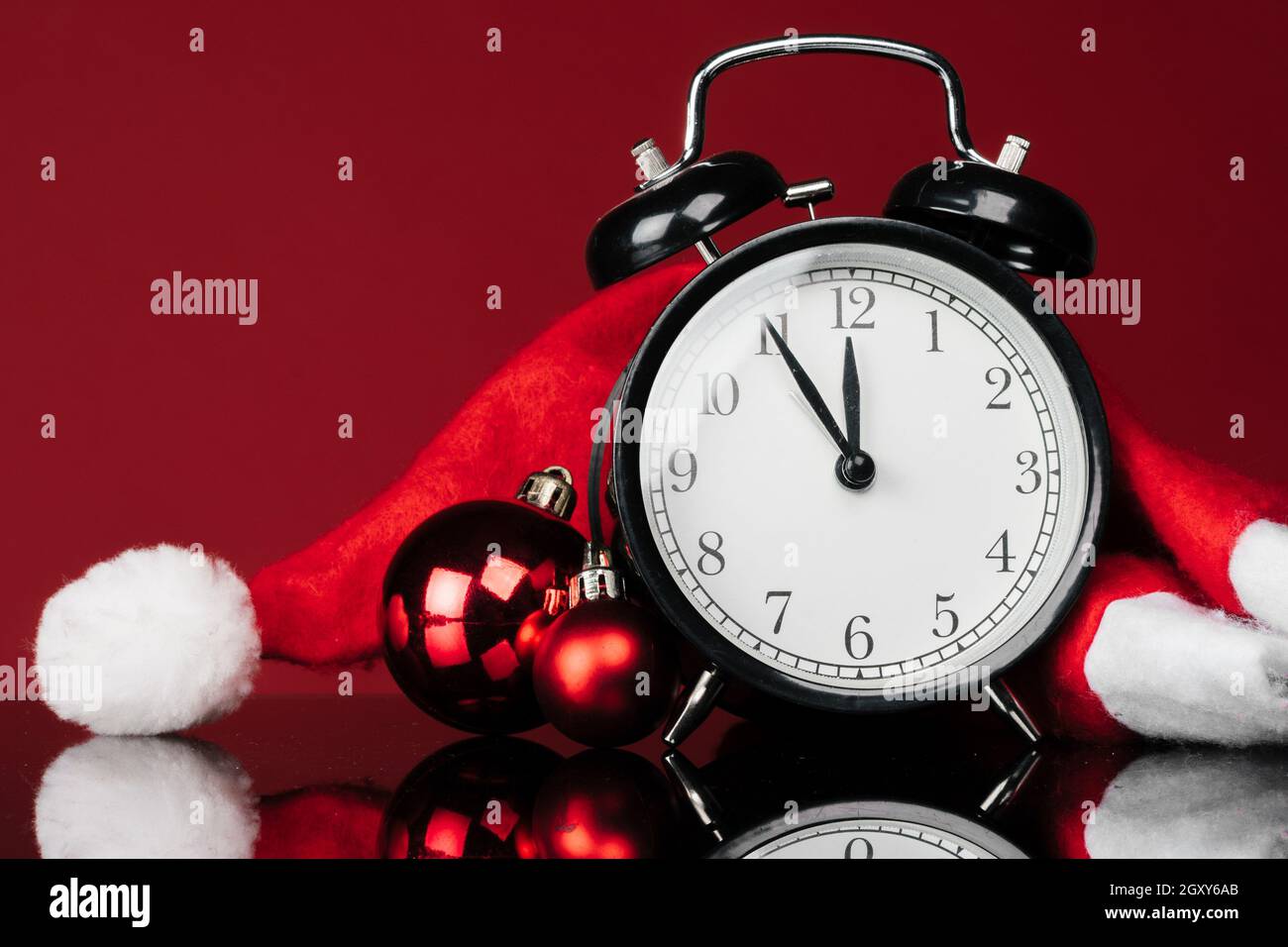 Black vintage alarm clock with christmas baubles and decor on dark ...