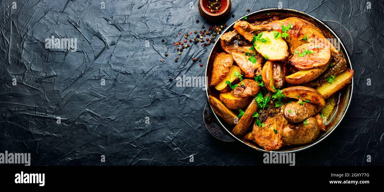 Appetizing chicken meat with potatoes roasted in a pan.Space for text ...