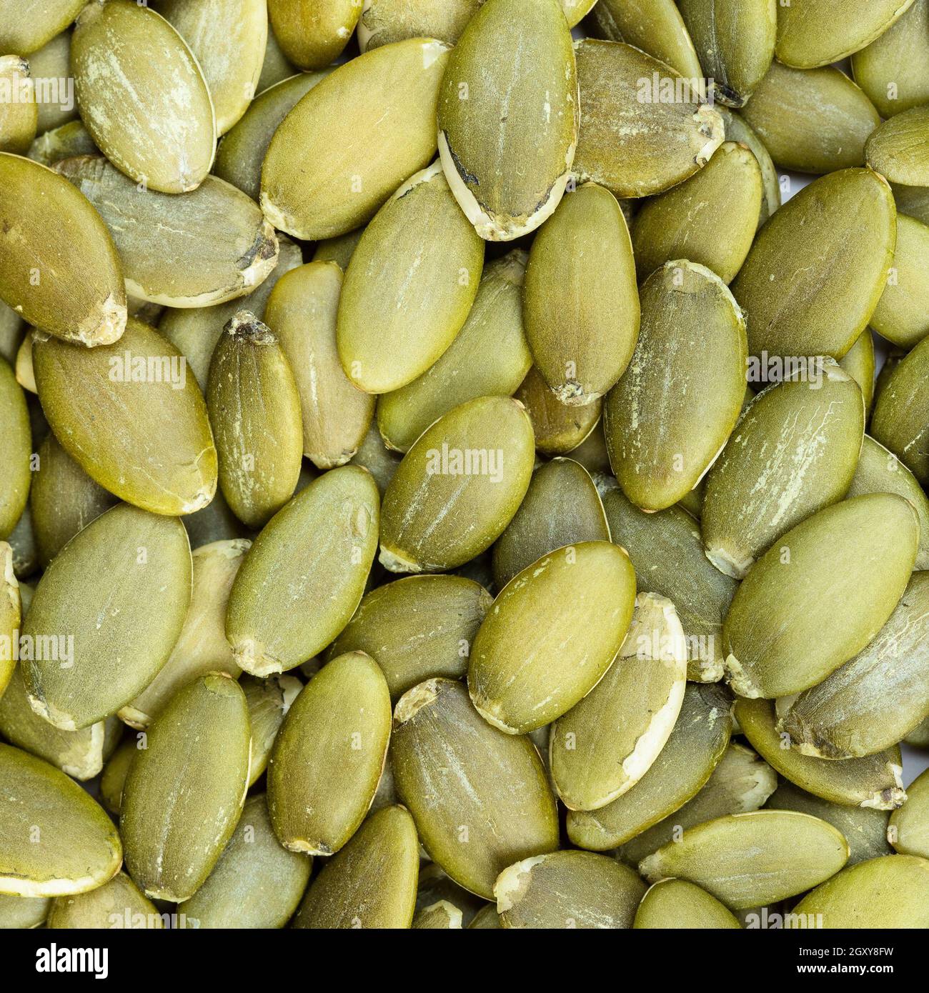 square food background - hulled pumpkin seeds close up Stock Photo - Alamy