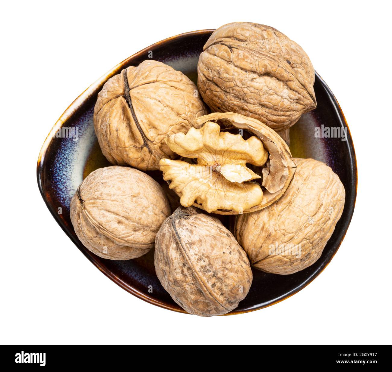top view of shelled and few whole walnuts in ceramic bowl isolated on ...
