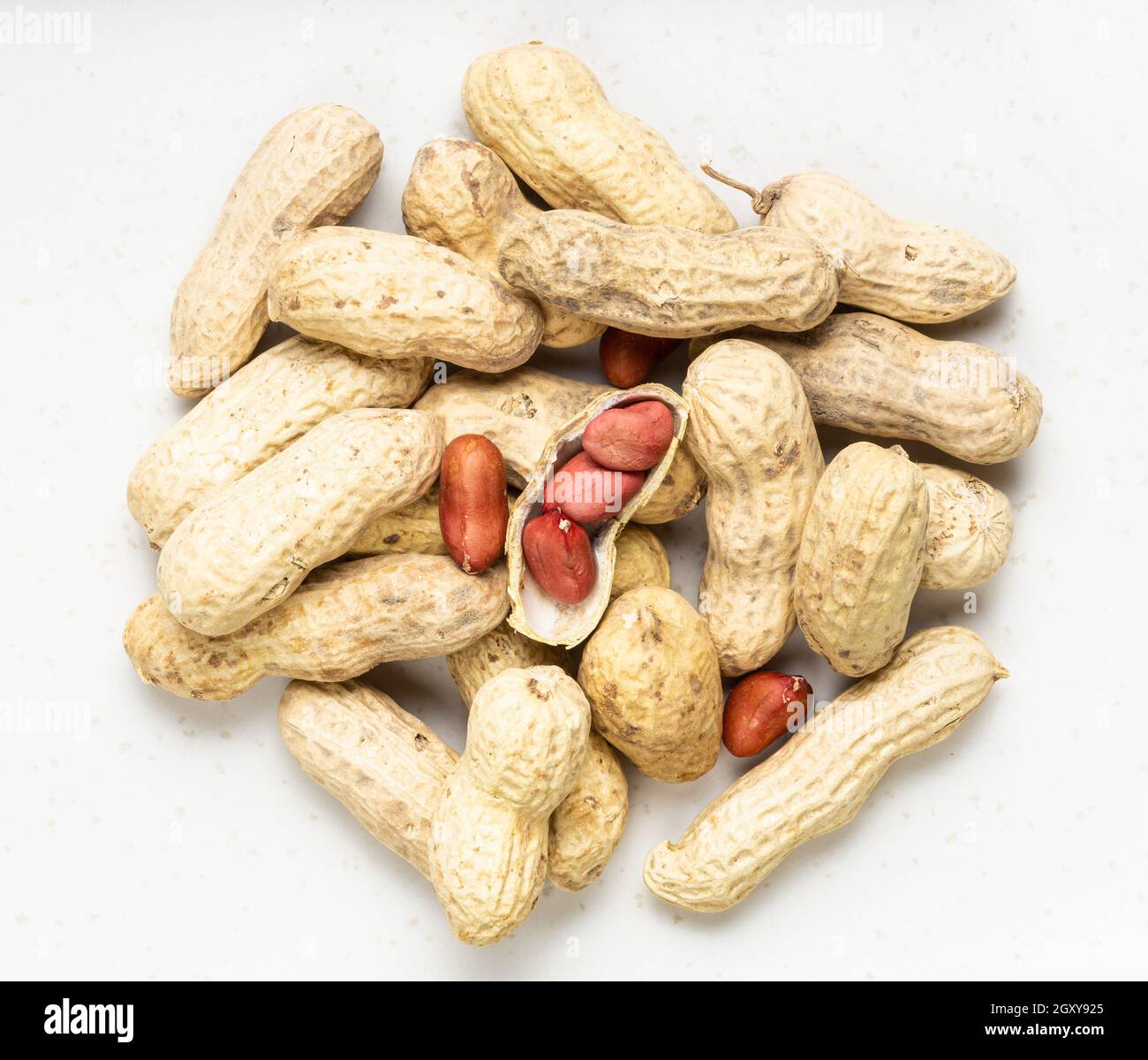 top view of pile of whole and peeled peanuts close up on gray ceramic ...