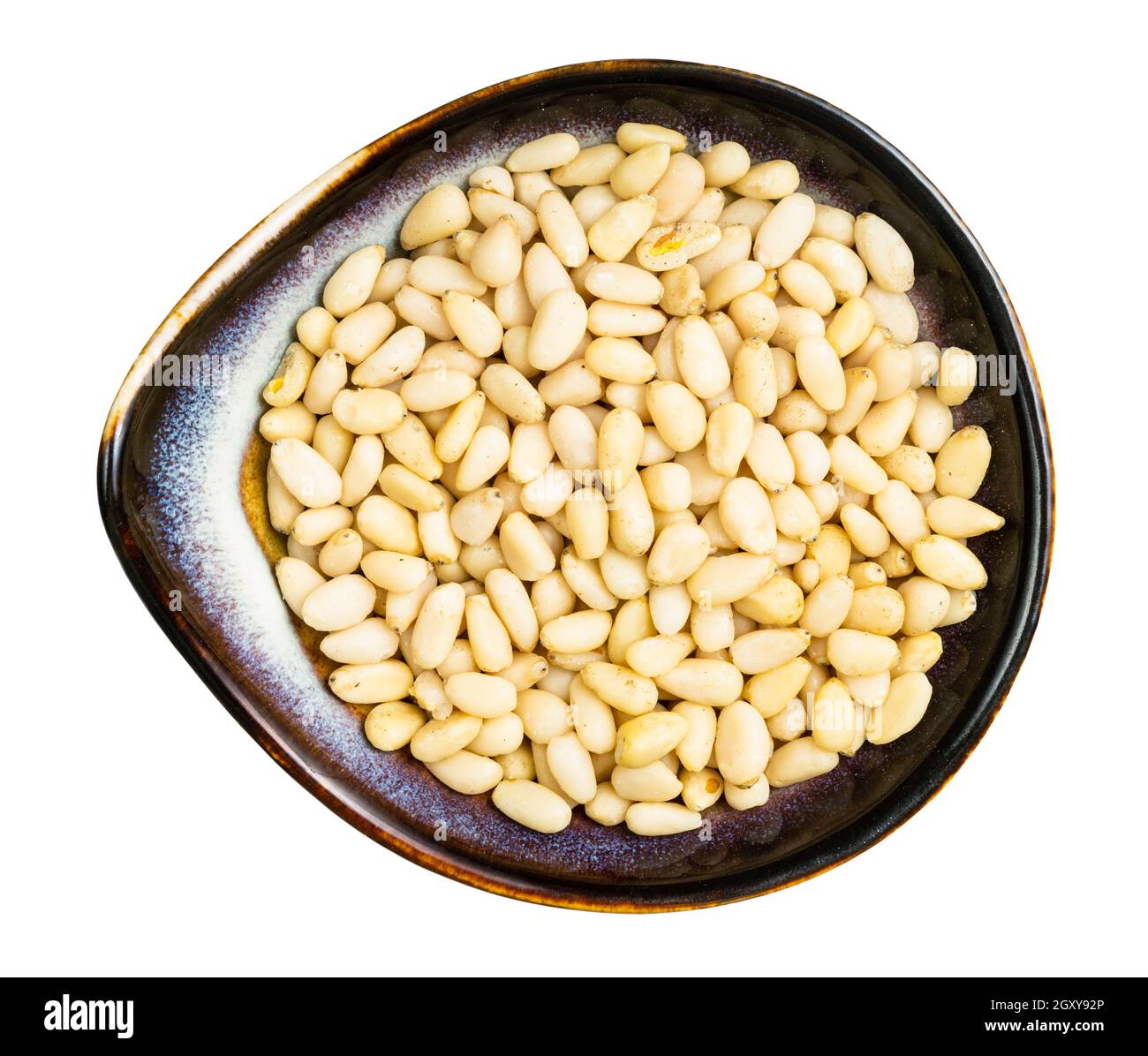 top view of shelled pine nuts in ceramic bowl isolated on white ...