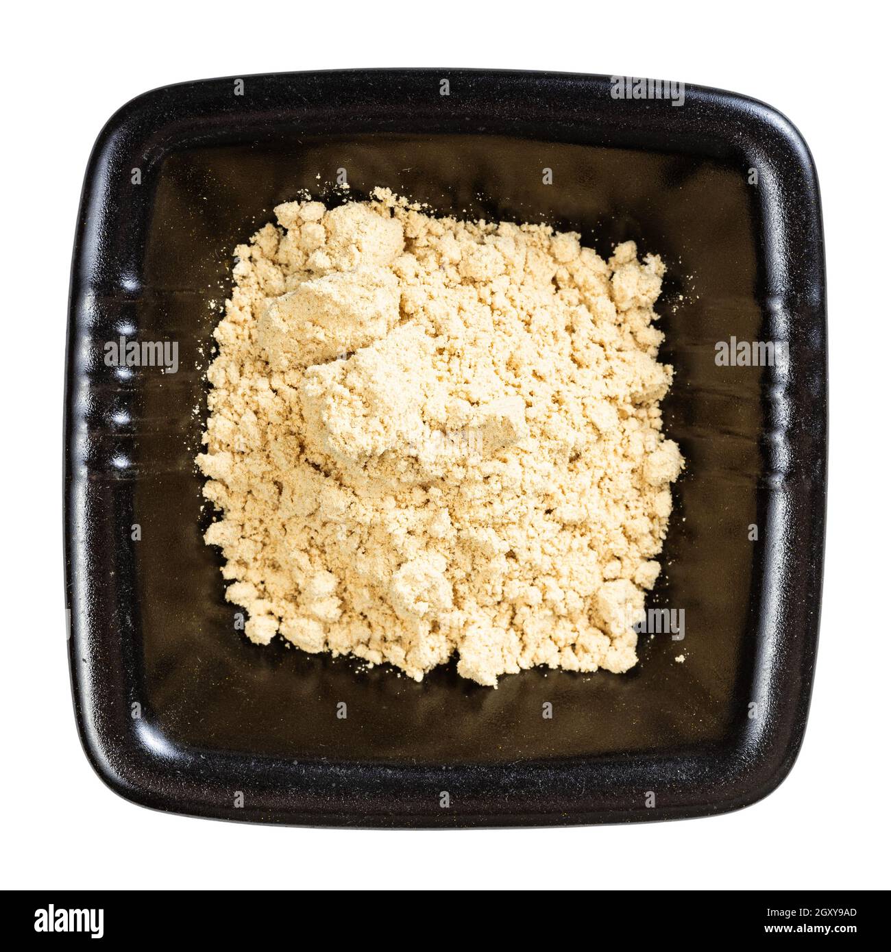 top view of ginger powder in black bowl isolated on white background ...