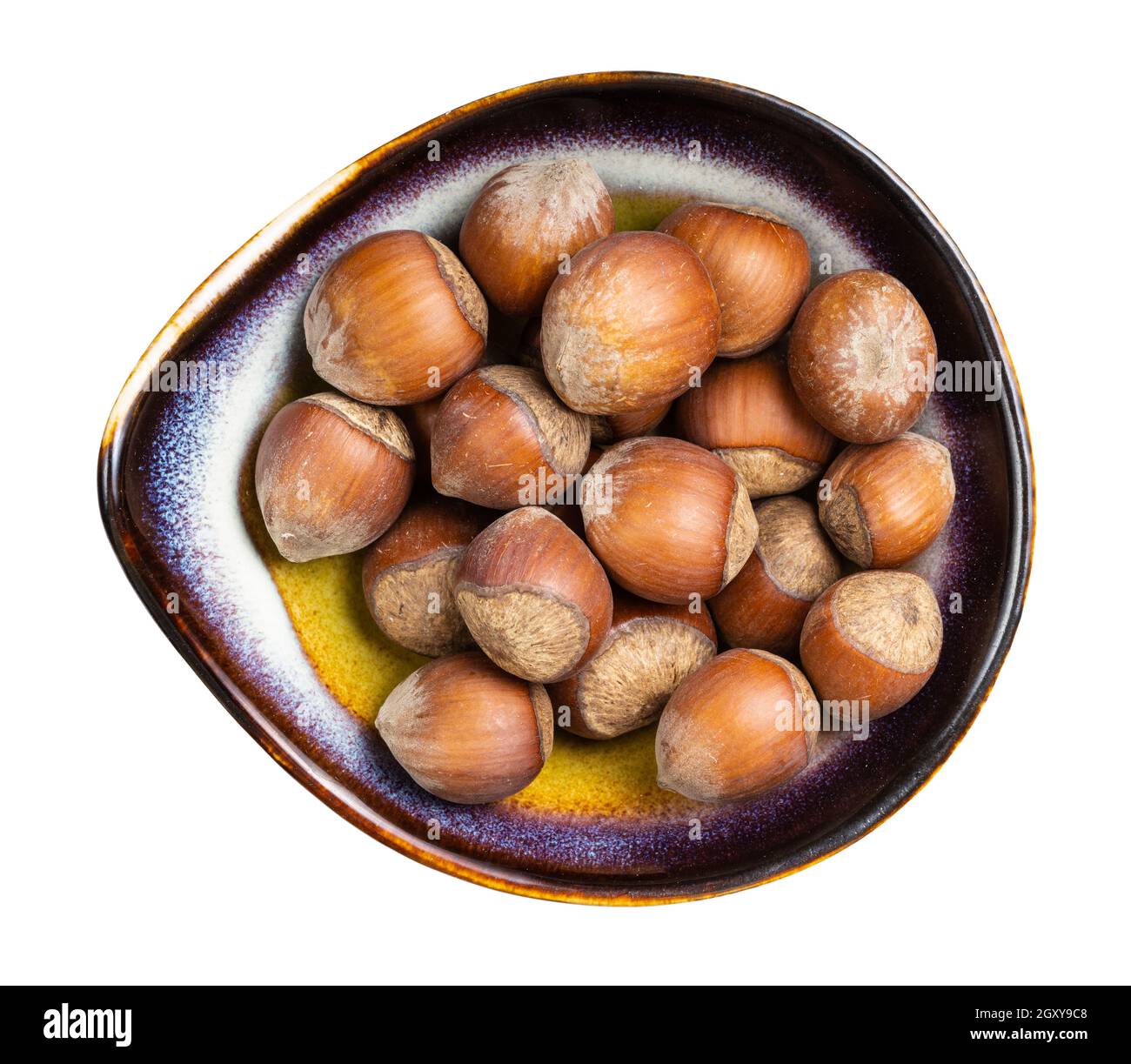 top view of whole hazelnuts in ceramic bowl isolated on white ...