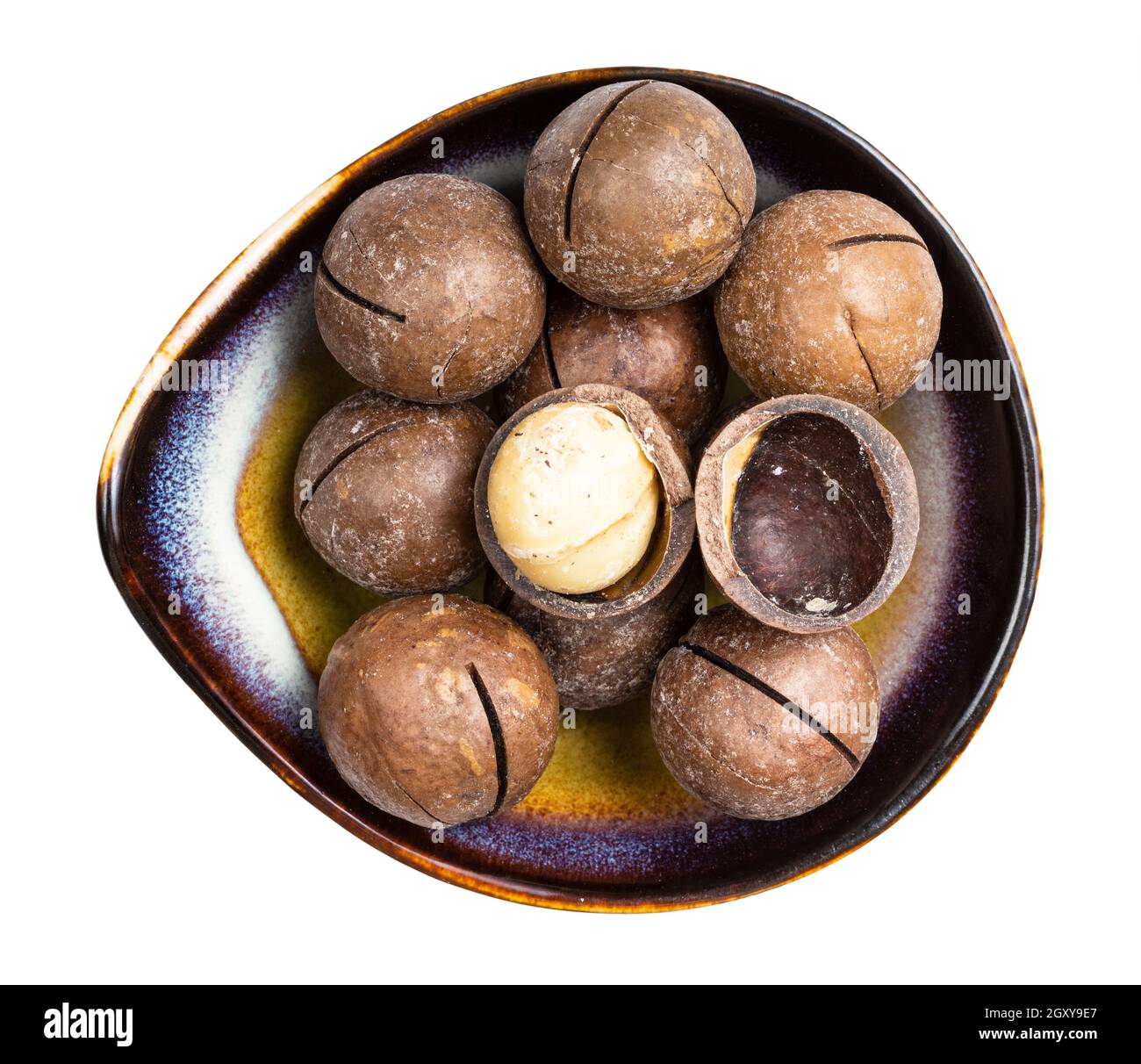 top view of sawn and shelled macadamia nuts in ceramic bowl isolated on ...