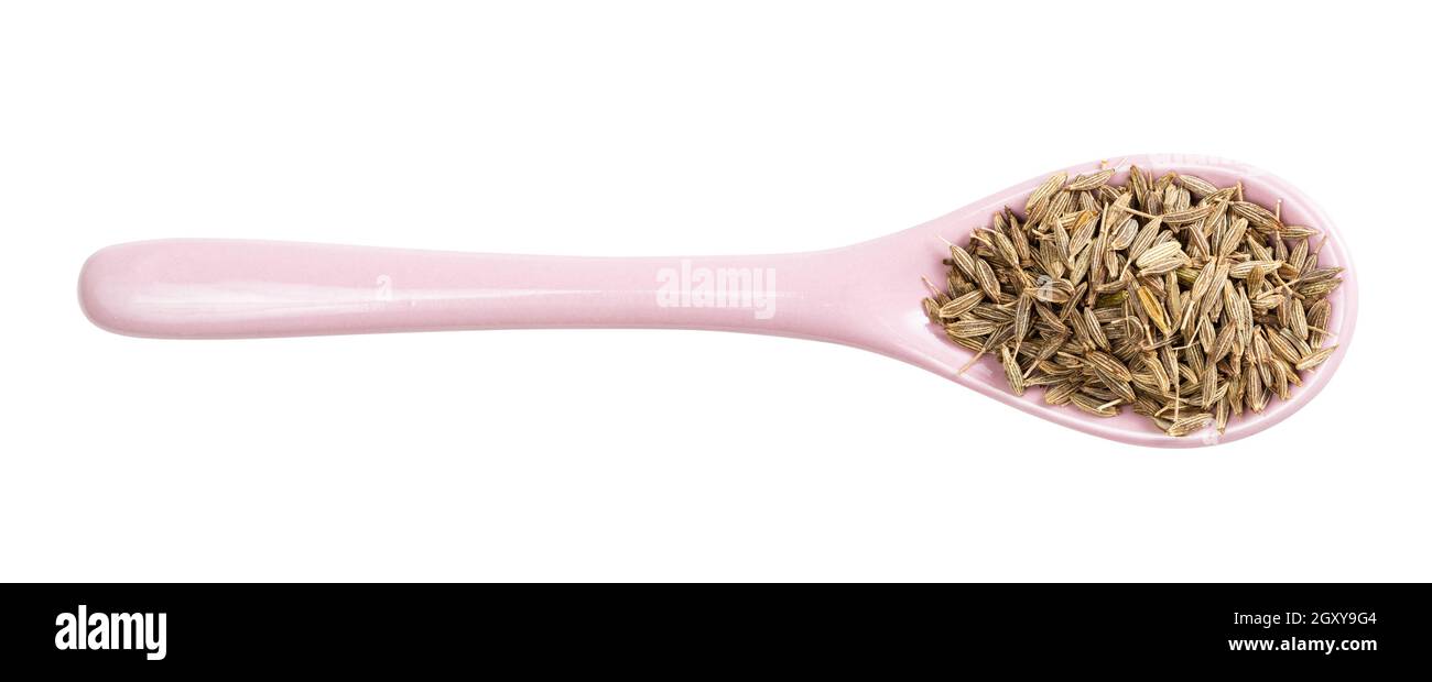 top view of ceramic spoon with cumin (cuminum cyminum) seeds isolated ...