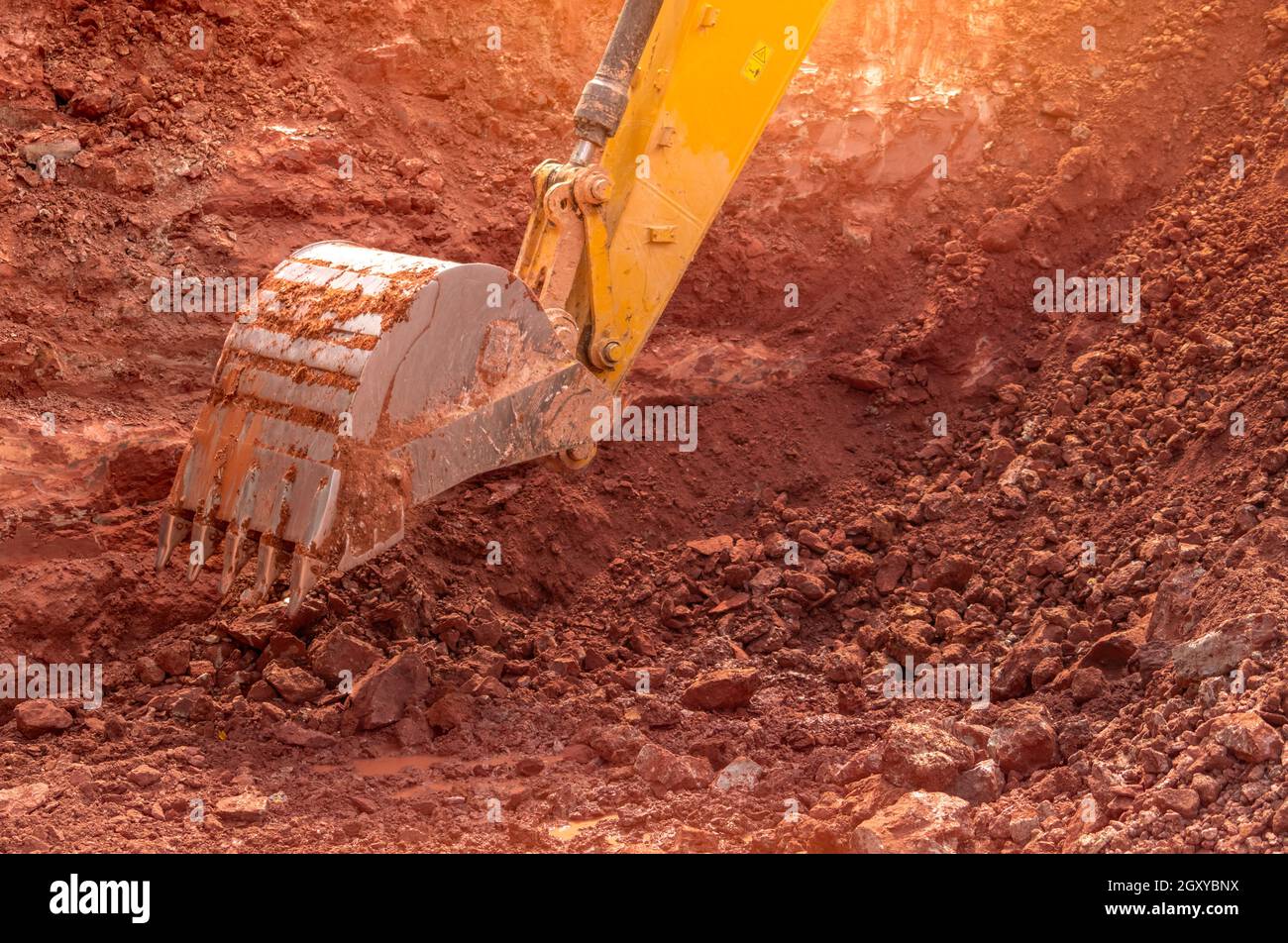 Backhoe working by digging soil at construction site. Bucket of backhoe ...