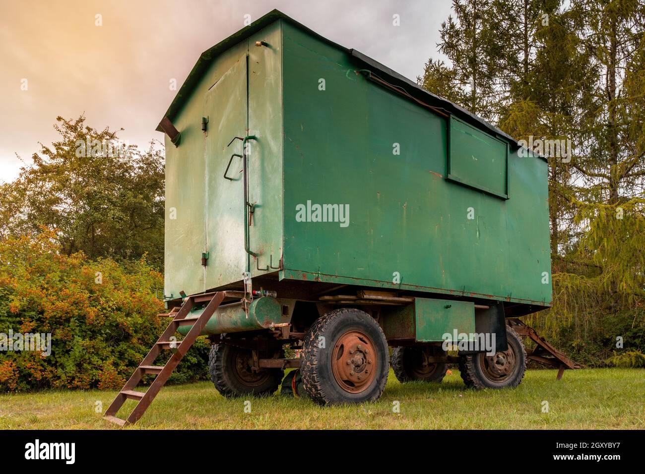 Old green rusty construction camper, trailer, van or wagon. Temporary ...