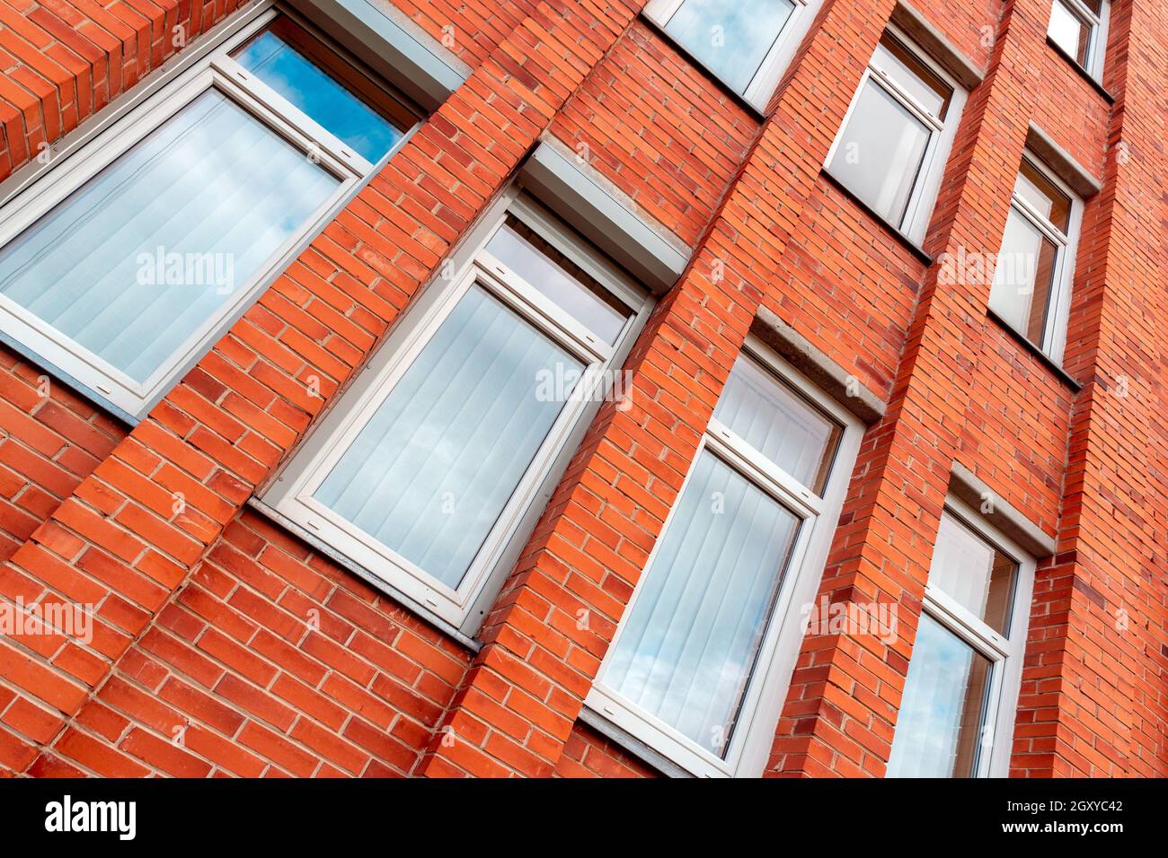 Red brick building wall with clouds reflections in windows Stock Photo ...