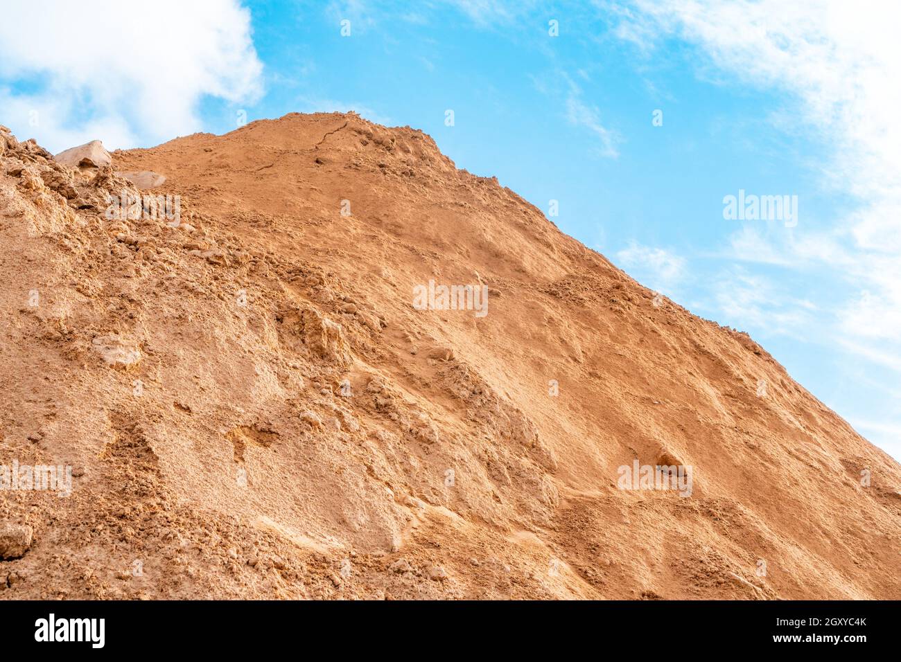 Heap in the quarry sand against the blue sky background Stock Photo - Alamy