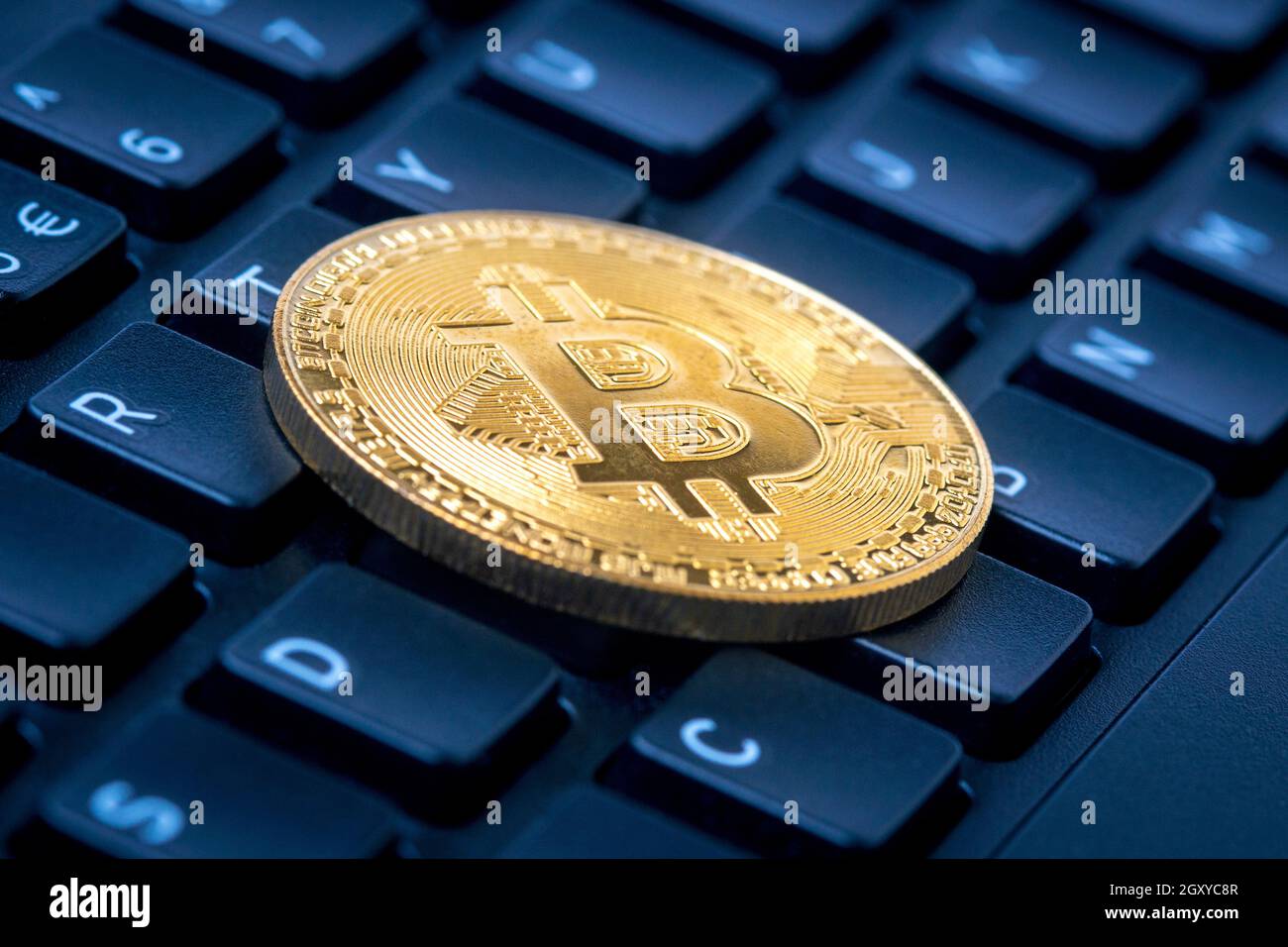 Bitcoin lying on computer keyboard , symbol of electronic virtual money ...