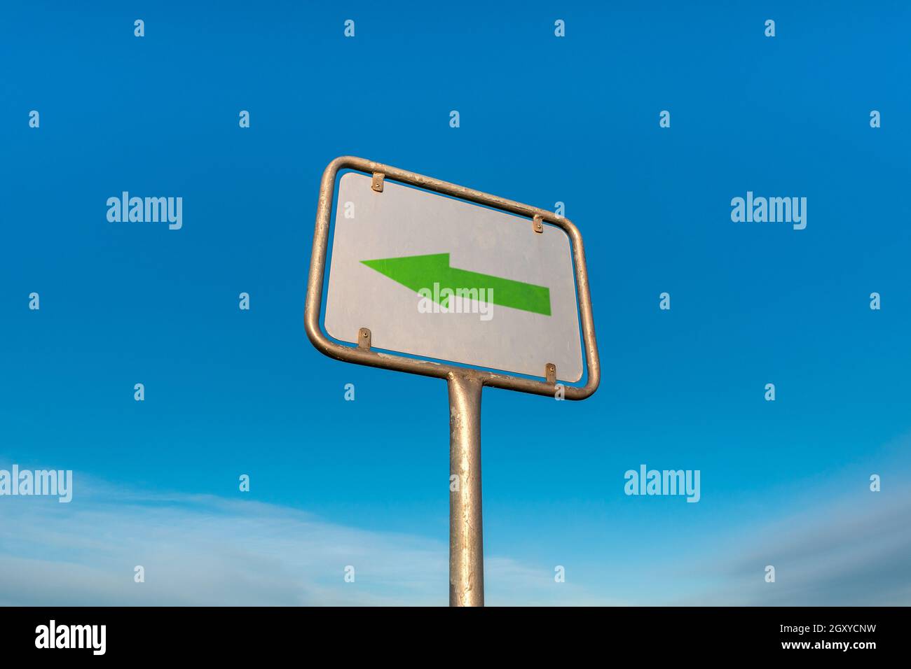 Left pointing direction sign on the blue sky background Stock Photo - Alamy