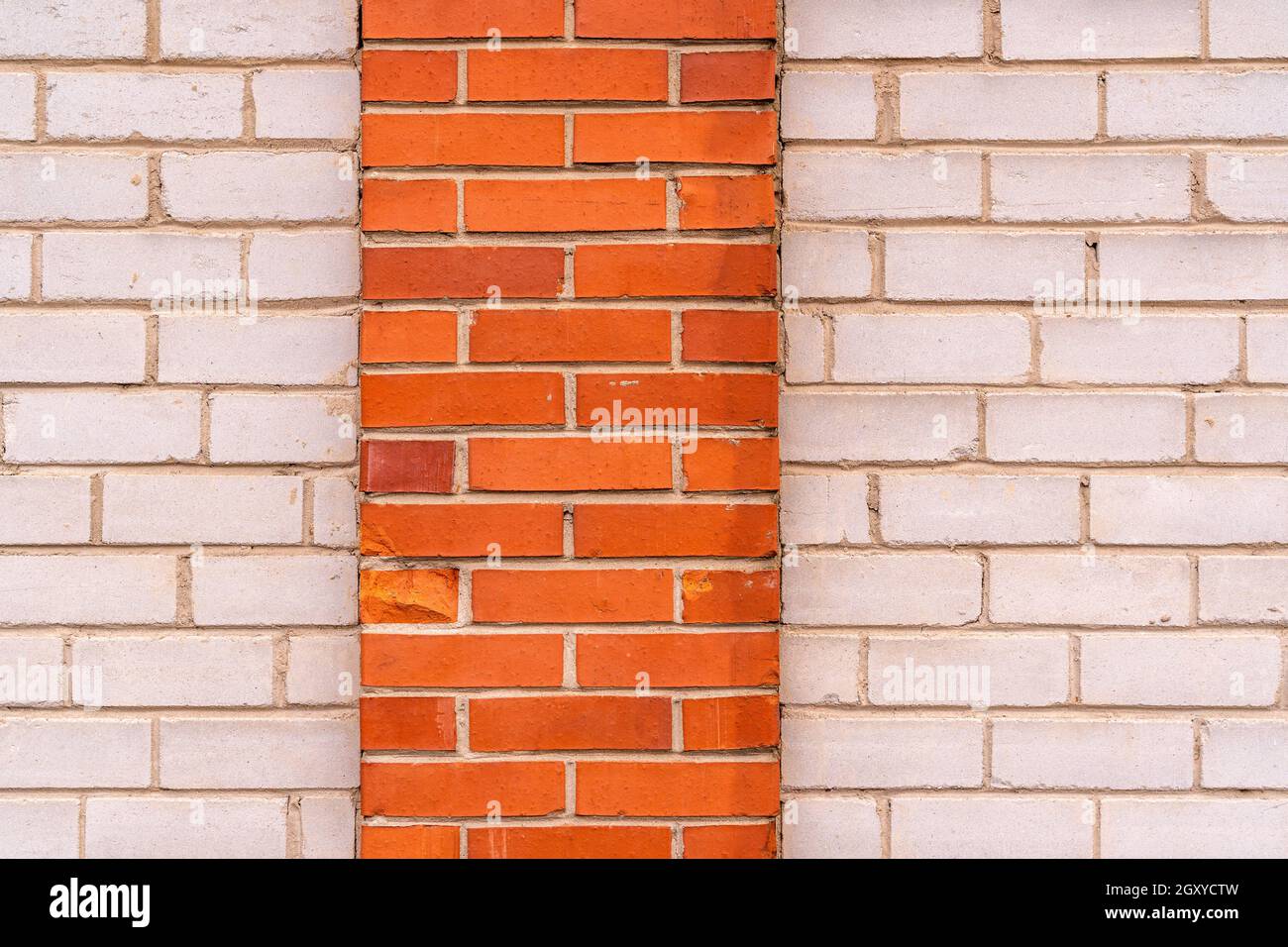 A wall of white brick with a strip of red bricks Stock Photo - Alamy