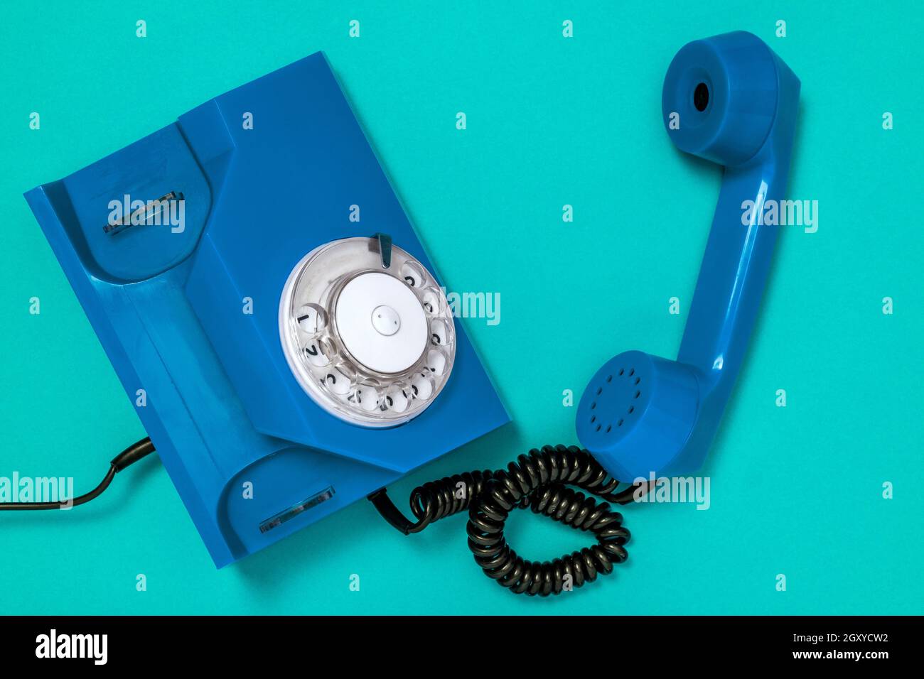 Old blue telephone rings with handset off Stock Photo - Alamy