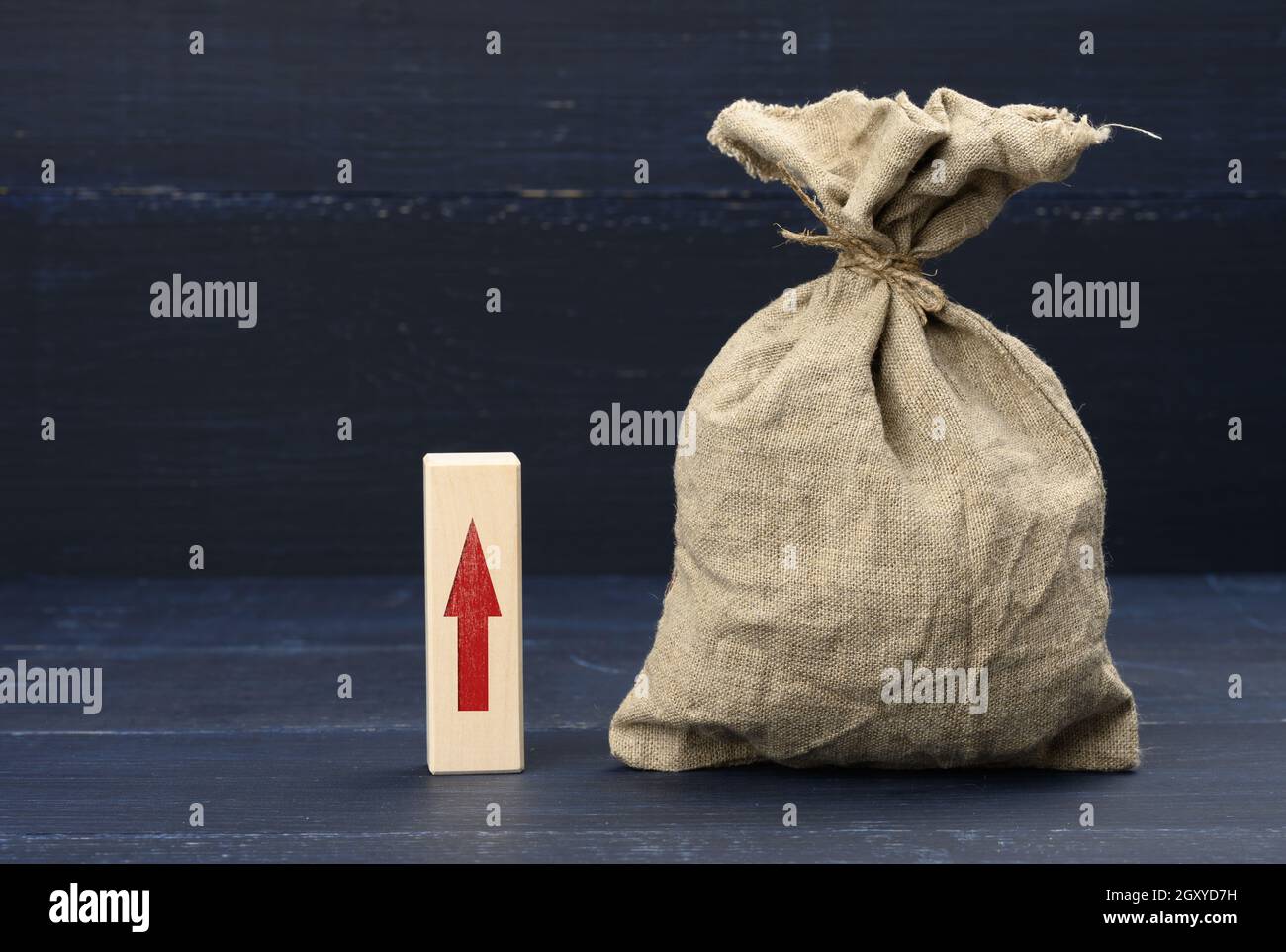 full sack and wooden block with a red arrow on a blue background ...