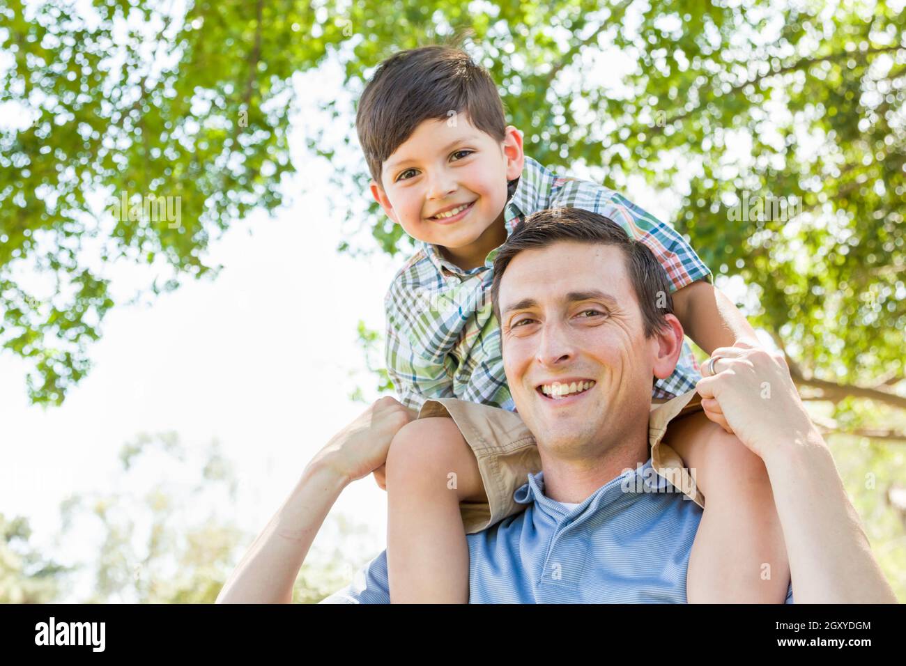 Mixed Race Father and Son Playing Piggyback Together in the Park Stock ...