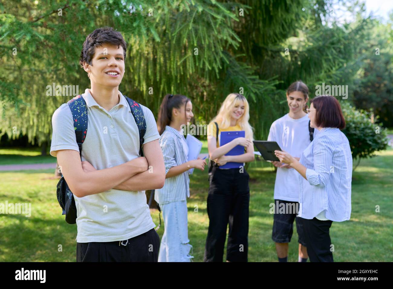 Portrait of male student in park campus, group of teenagers with ...
