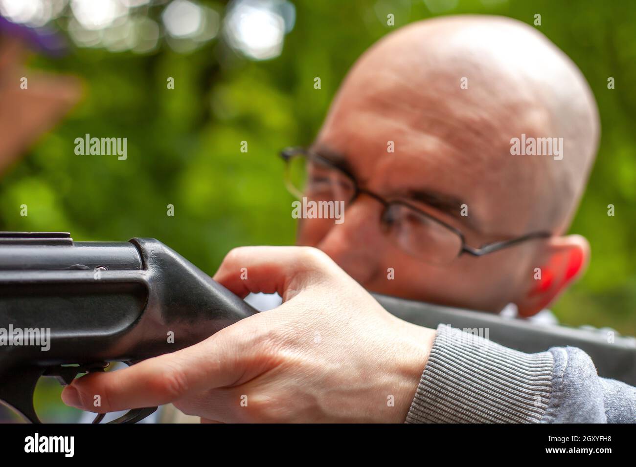 Young man shooting a gun. Man aiming with shotgun on shooting range ...