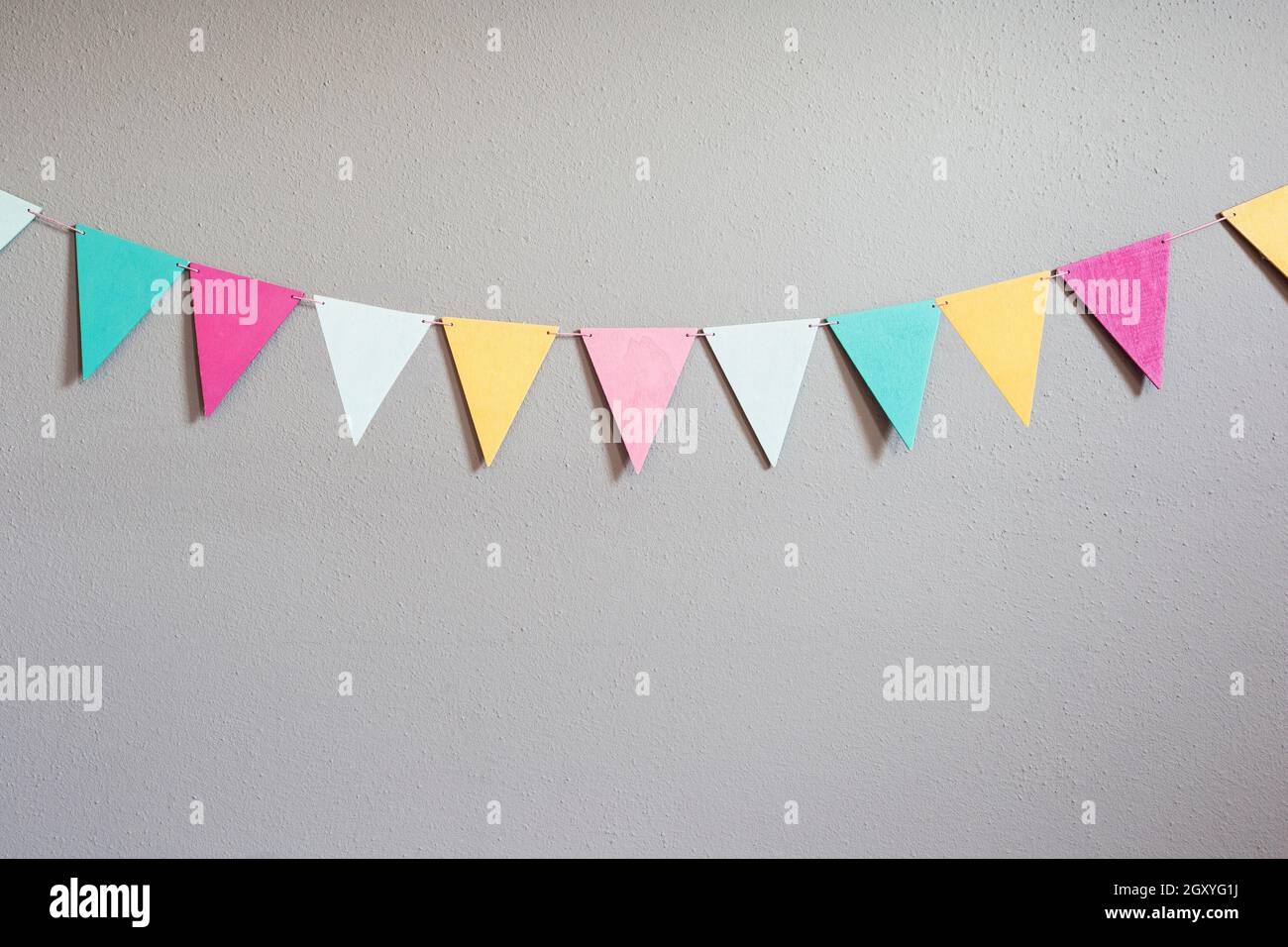 Colorful party flags over cement concrete gray wall texture background ...