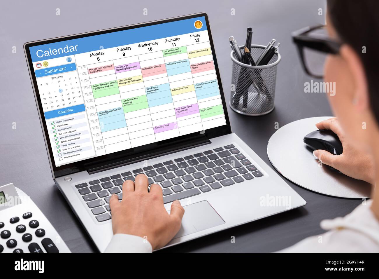 Executive Looking At Calendar On Computer. Arranging Weekly Schedule ...