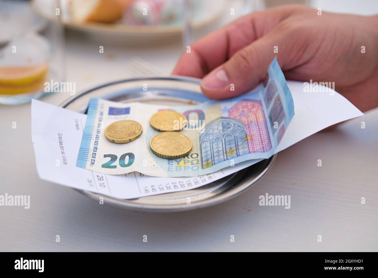 Hand bringing back the metal bill tray with the change Stock Photo - Alamy