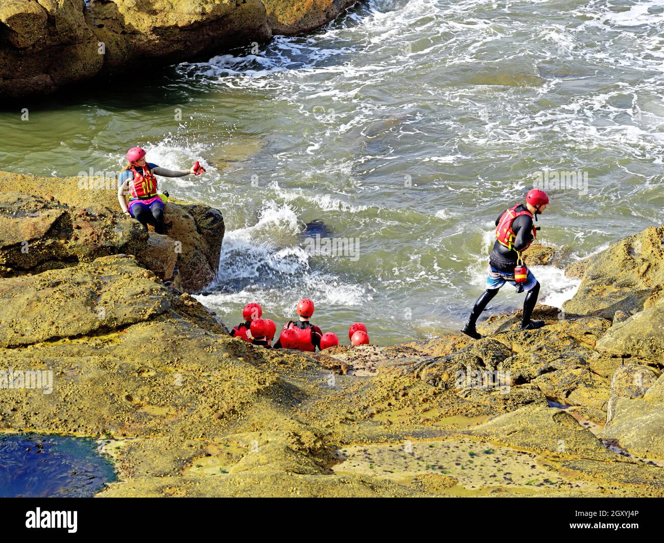 Adults learning coastal tidal walking and survival at Cullercoats Stock ...