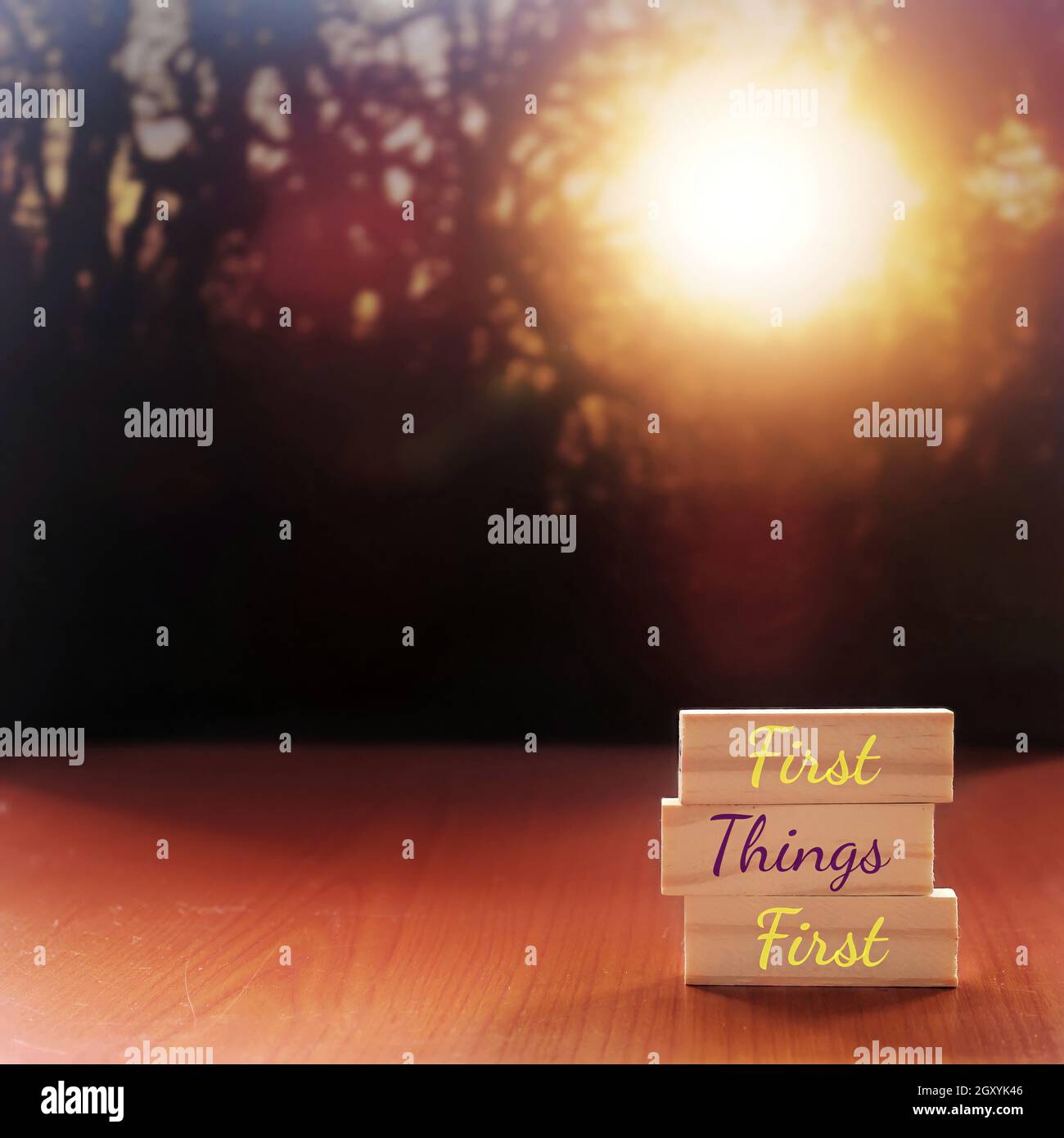 Text FIRST THINGS FIRST on wooden tiles with background of sunrise and ...