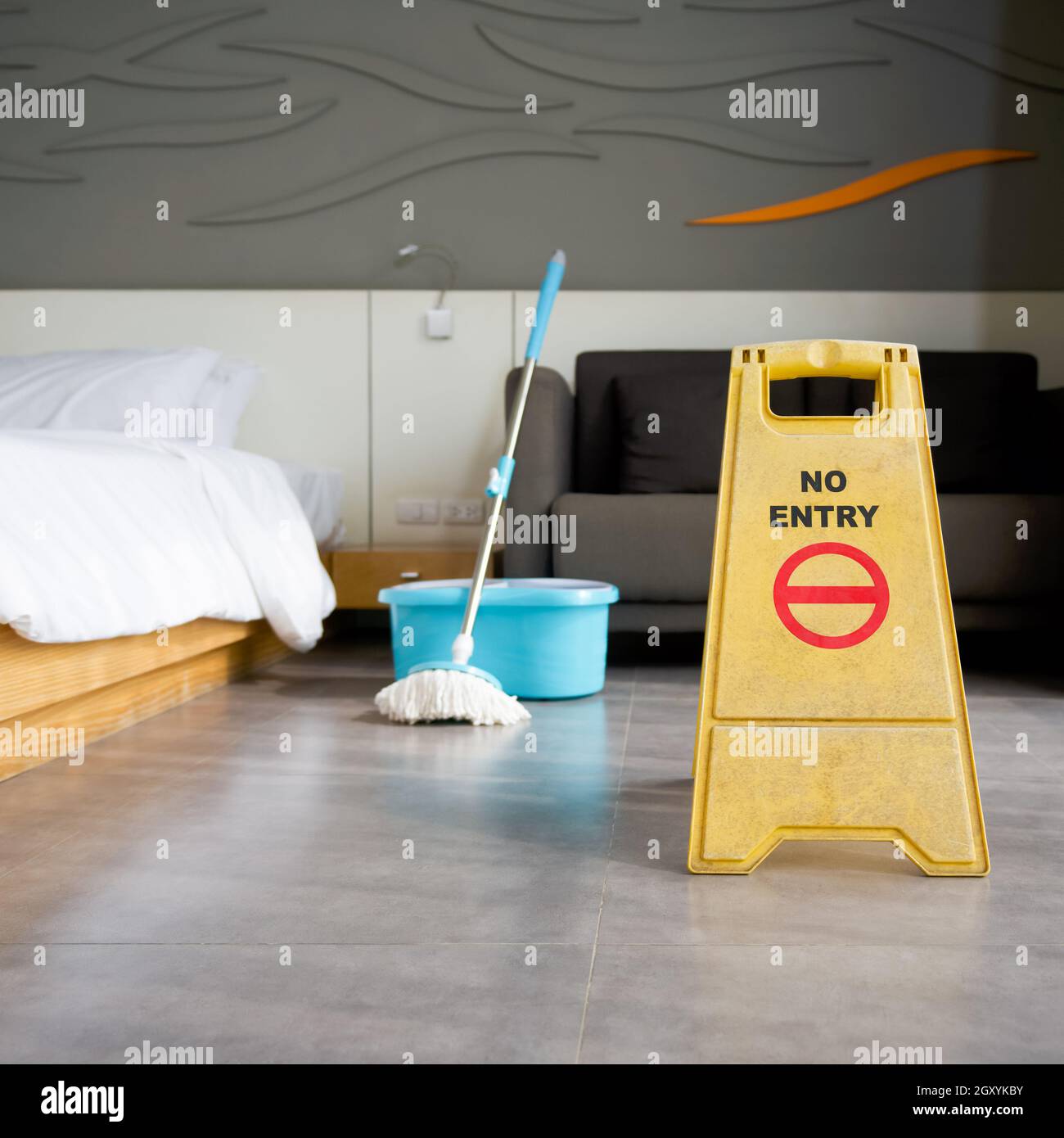 A yellow "NO ENTRY" sign place on the floor in hotel room. While ...