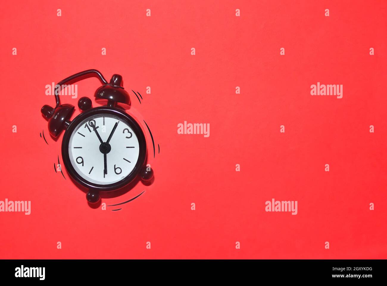 Black alarm clock on red background with loud and vibrating effect ...