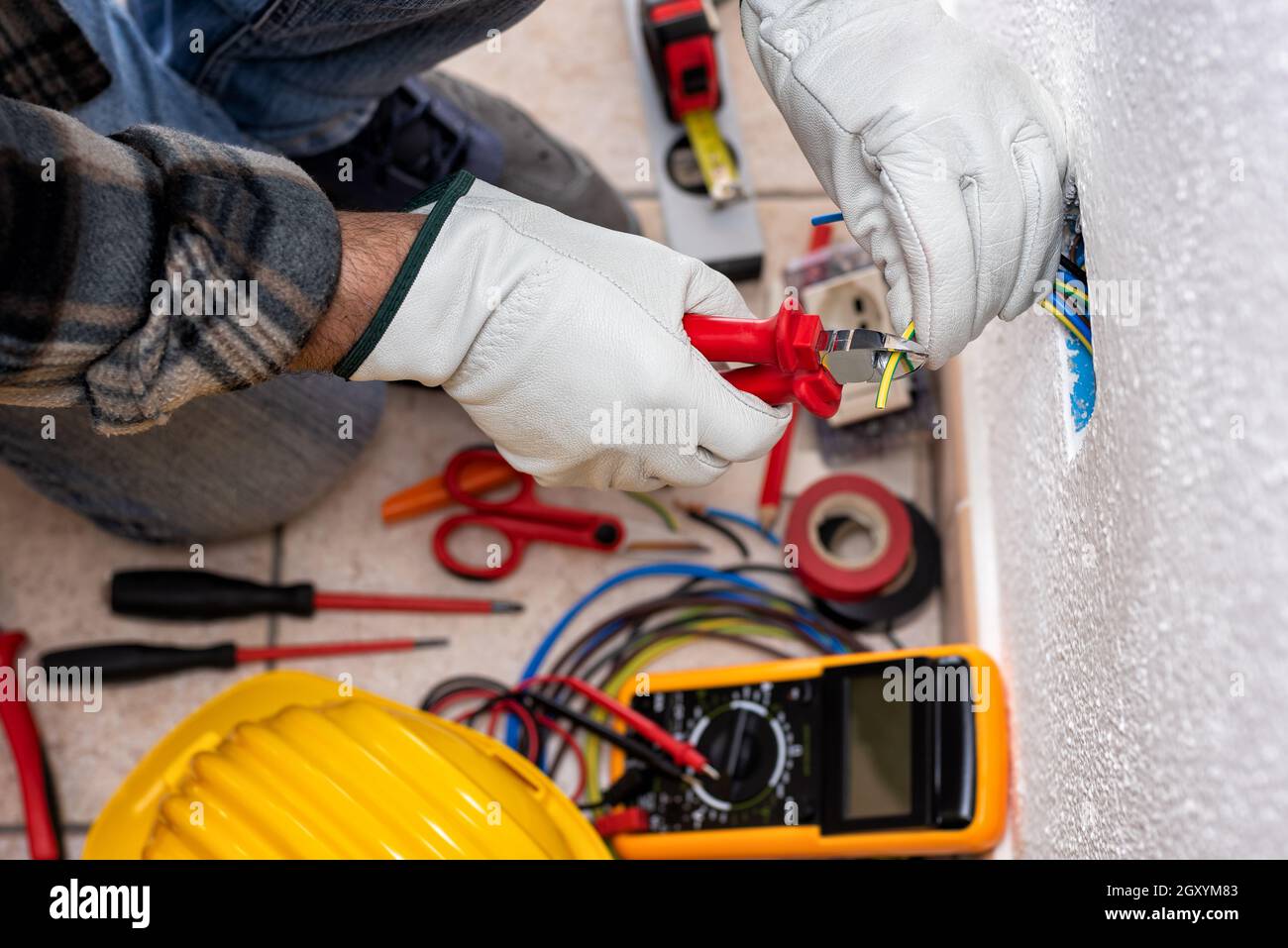 Top view. Electrician worker at work with cable cutter prepares the ...