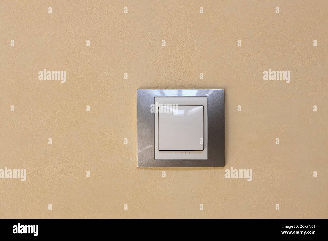 Fashionable modern white light switches in silver frame on beige ...