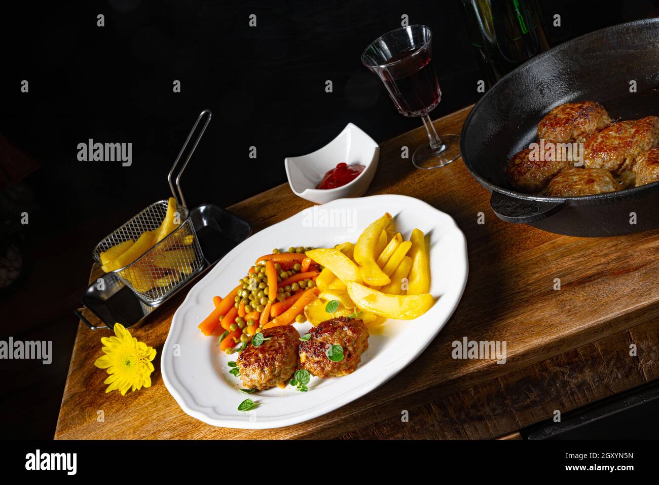 Homemade meatballs with french fries and vegetables Stock Photo - Alamy