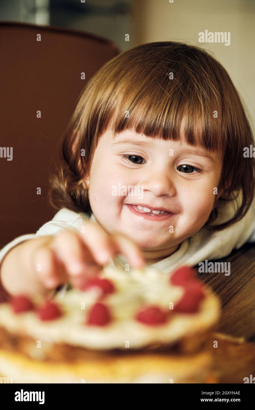 Cute Happy Baby Girl Eating Cake With Raspberries. Adorable little girl ...