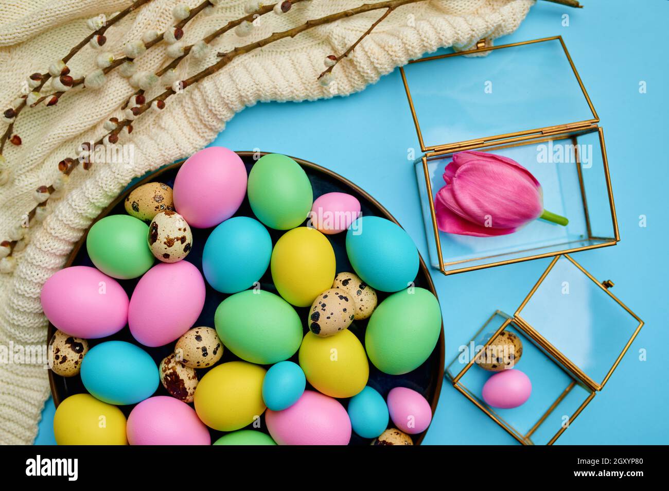 Colorful easter eggs and floral decoration on blue background. Paschal ...