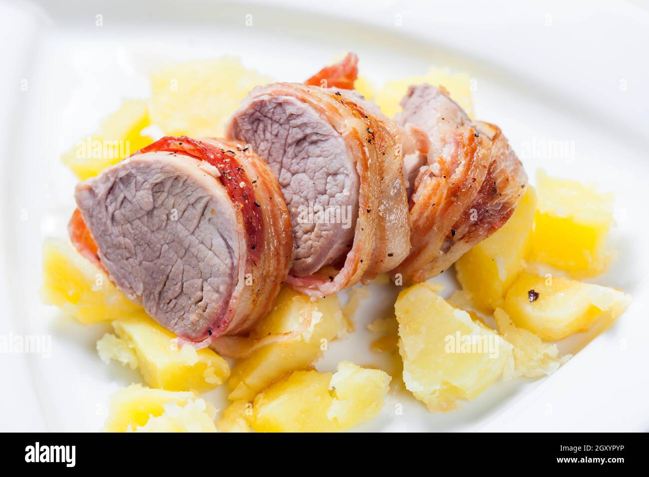 pork roll wrapped in bacon with potatoes Stock Photo - Alamy