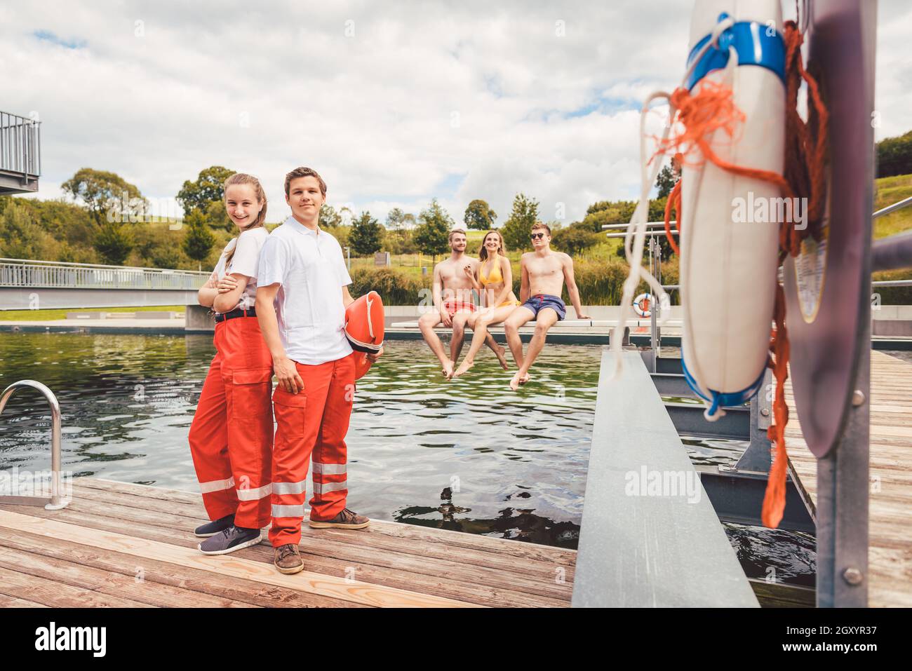 Lifeguards standing on the side of pool ready to help Stock Photo - Alamy