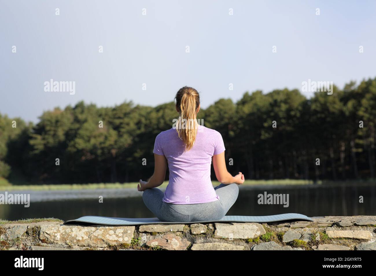 Back view of a woman doing yoga exercise in nature a sunny day Stock ...