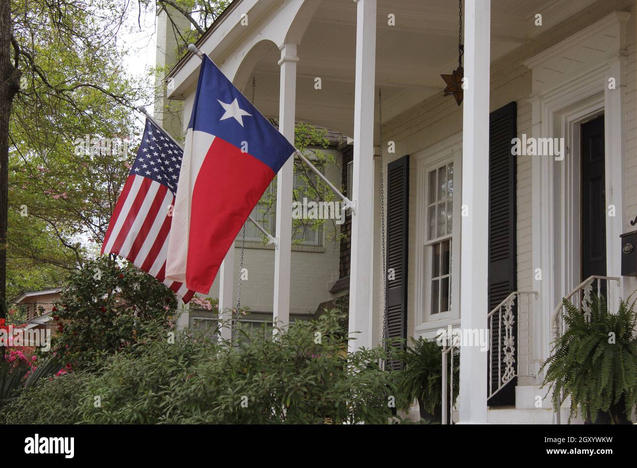 Historic Home With Texas and American Flags Springtime Stock Photo - Alamy