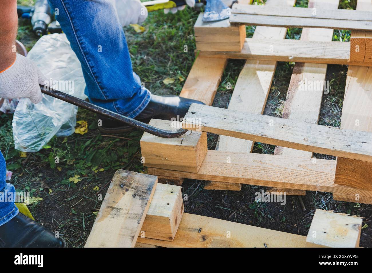 Working with wooden pallets. A man breaks a board in a pallet Stock ...