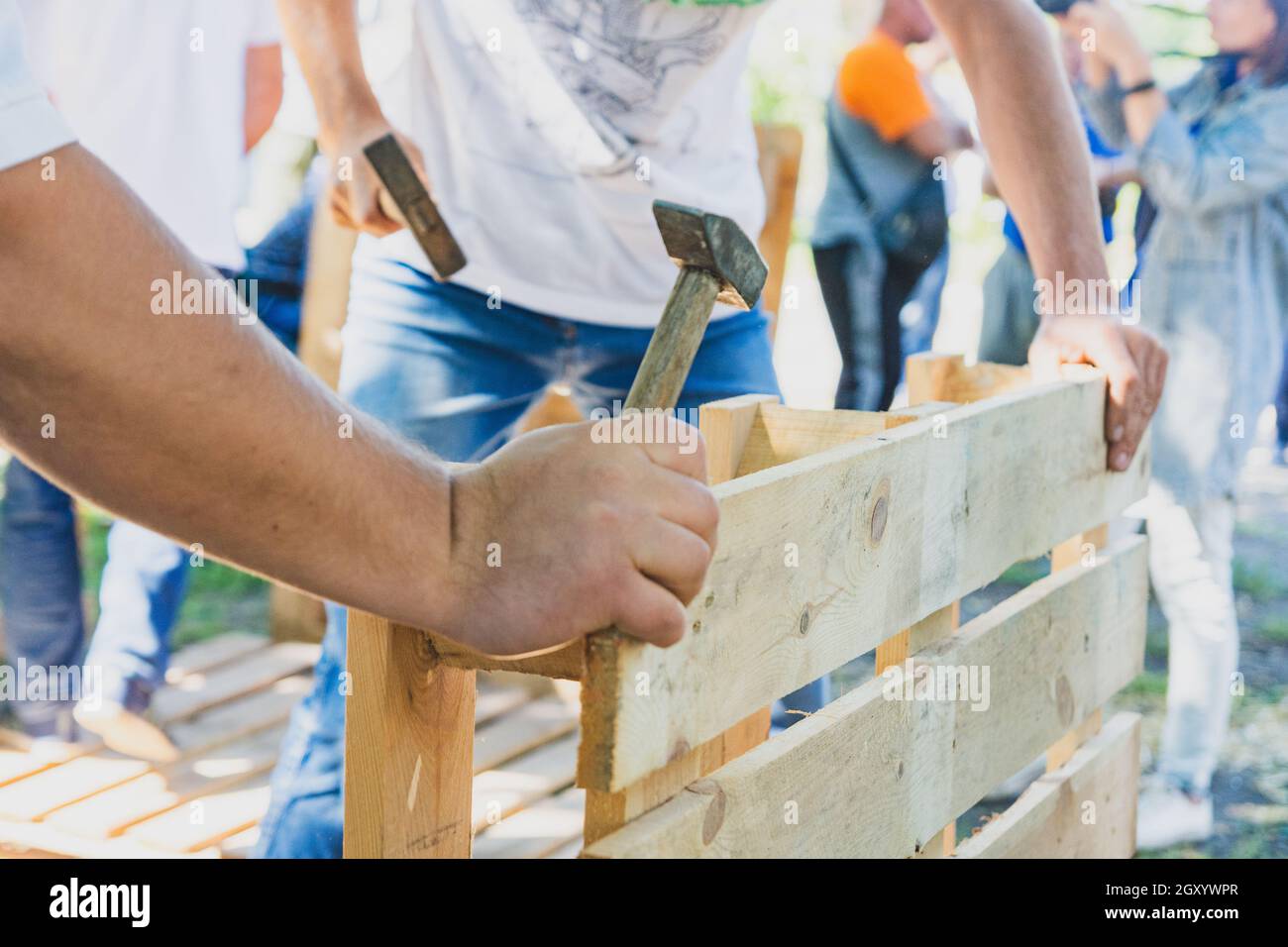 A man with a hammer works with pallets Stock Photo - Alamy