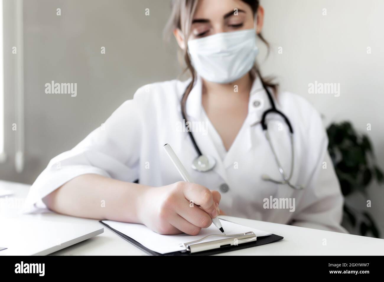 The doctor in shite dress with stethoscope and face protective mask ...