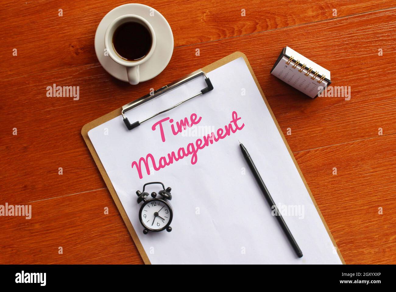 Top view of alarm clock, calendar, cup of coffee and paper clipboard ...